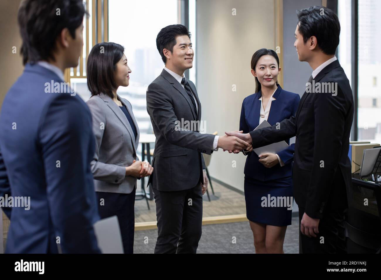 Successful Chinese business people shaking hands in office Stock Photo ...