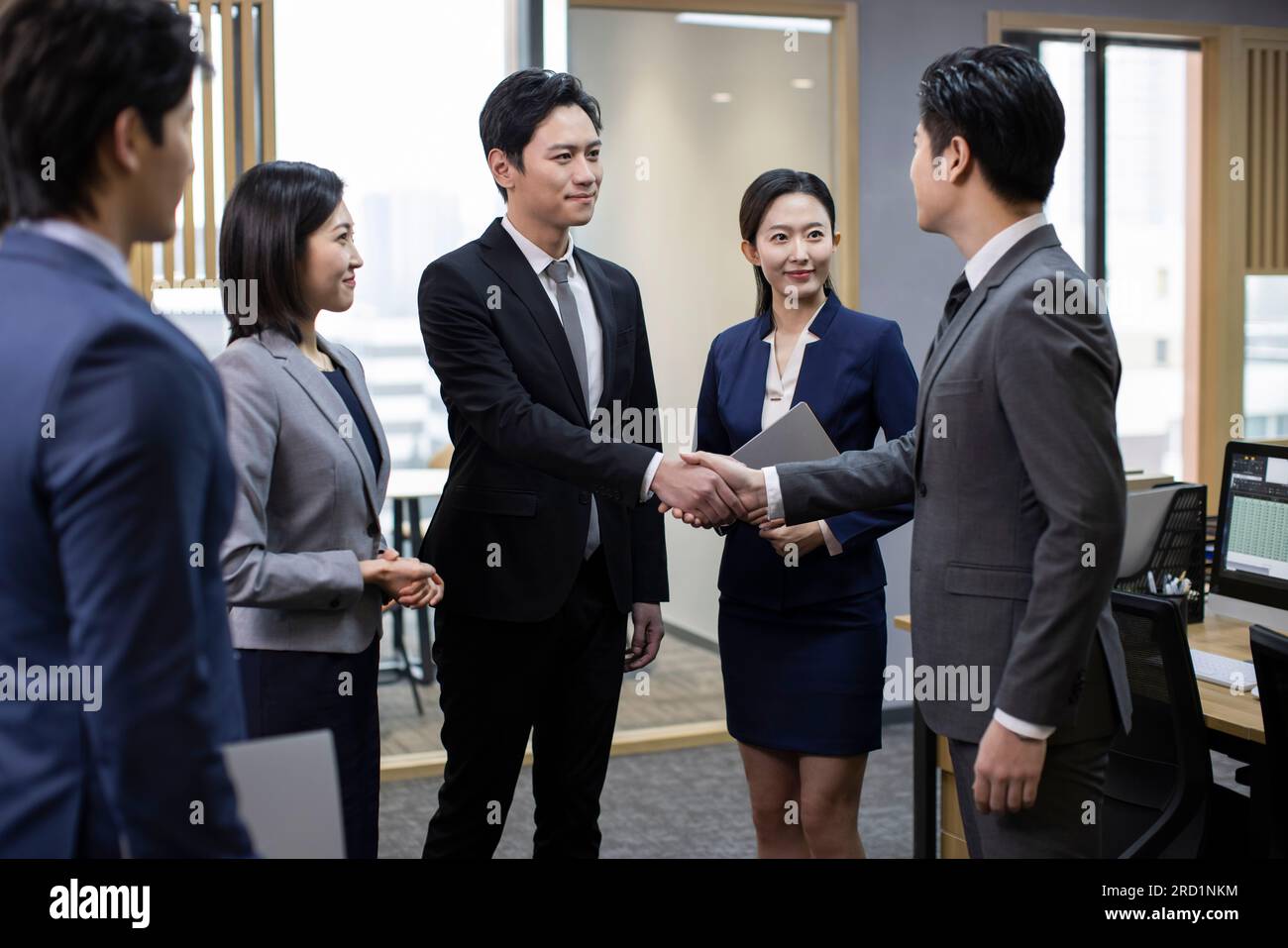 Successful Chinese business people shaking hands in office Stock Photo ...