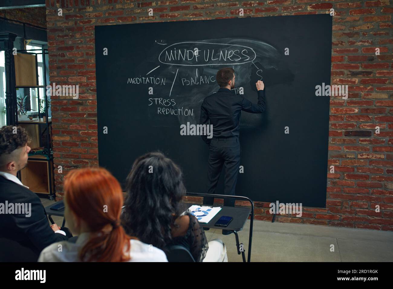 Young man writing on blackboard tips and components of mindfulness set ...