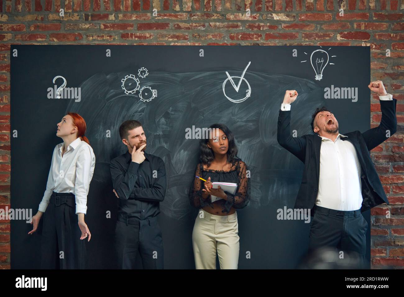 Group of employees standing by blackboard with drawn business icons ...