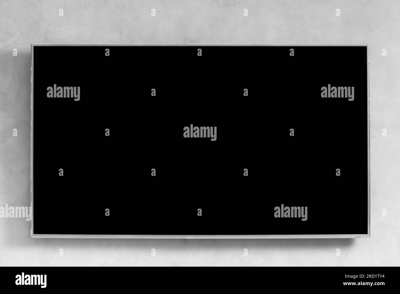 A modern smart TV with a chrome frame on a gray textured wall with a ...