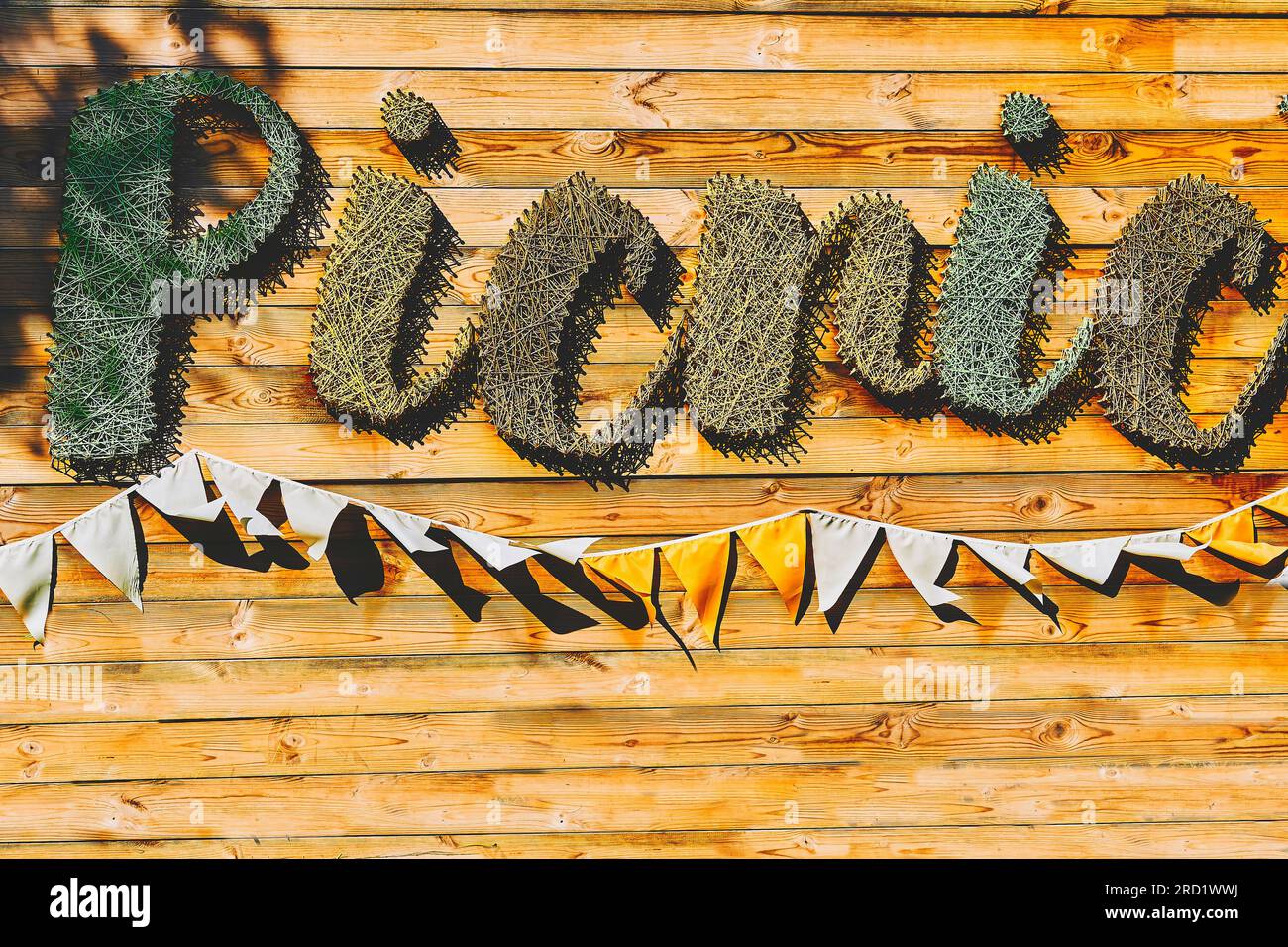 Cheerful inscription picnic on the wall of wooden boards with flags ...