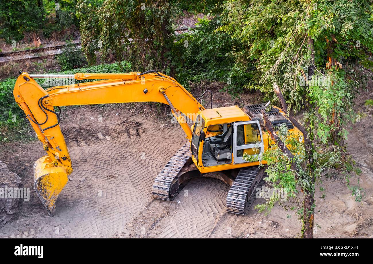 Heavy modern yellow digger excavator on building site Stock Photo - Alamy