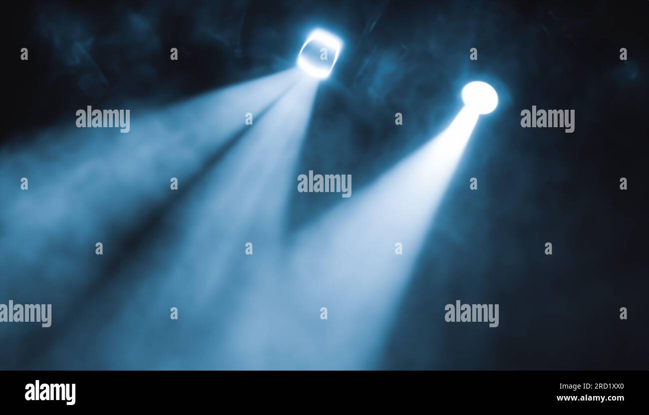 projectors light beam through smoke on stage Stock Photo - Alamy