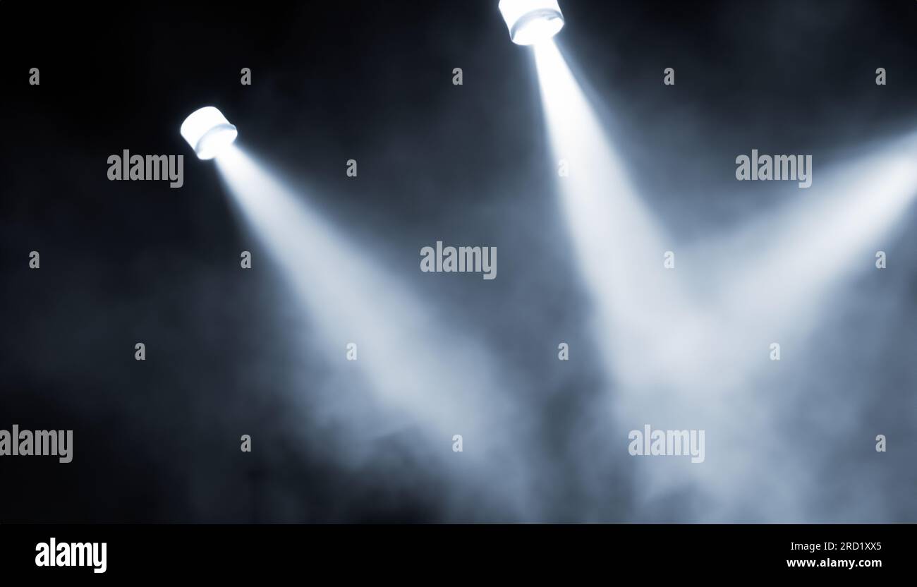 projectors light beam through smoke on stage Stock Photo - Alamy