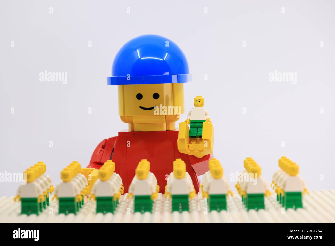 Giant man pick up the small one in the crowded people Stock Photo - Alamy