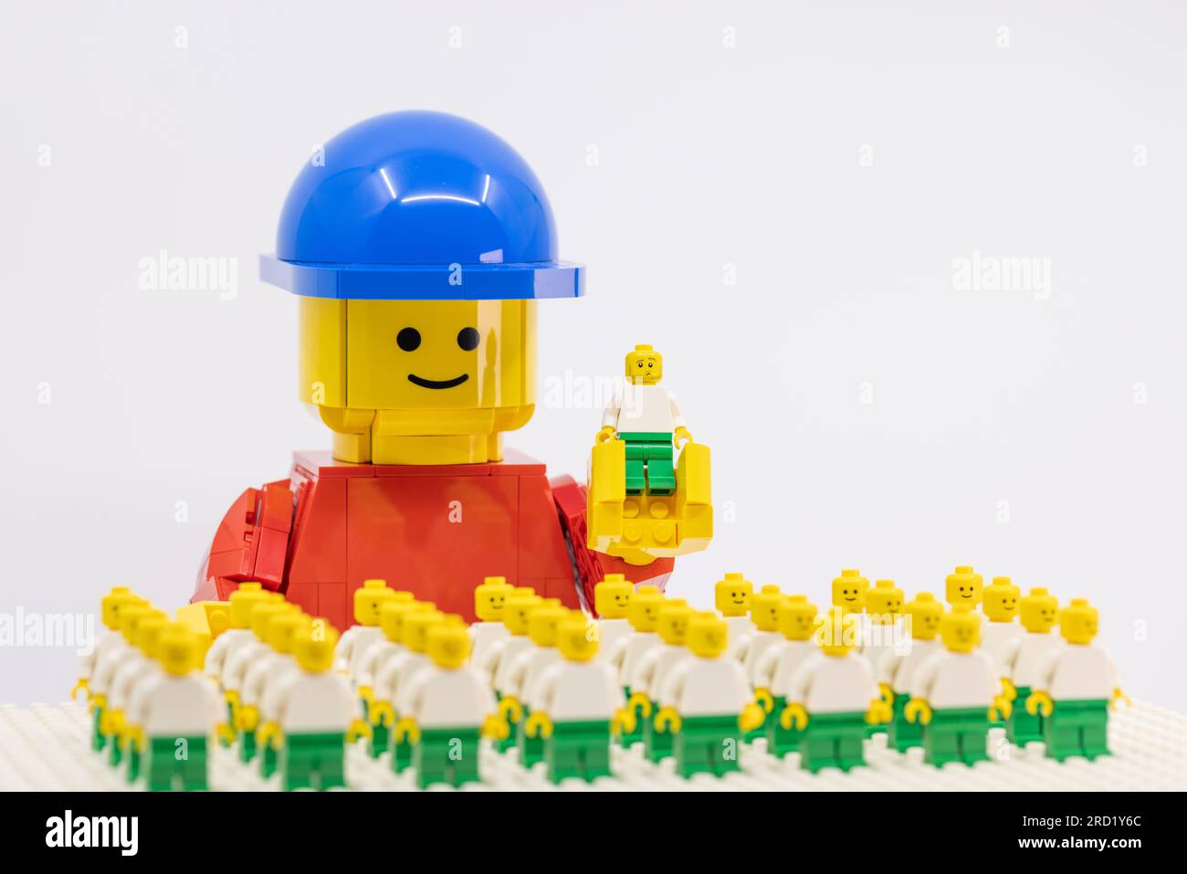 Giant man pick up the small one in the crowded people Stock Photo - Alamy