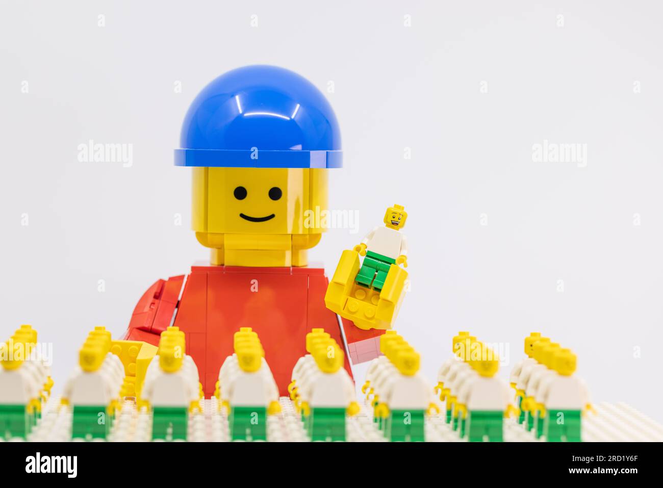 Giant man pick up the small one in the crowded people Stock Photo - Alamy