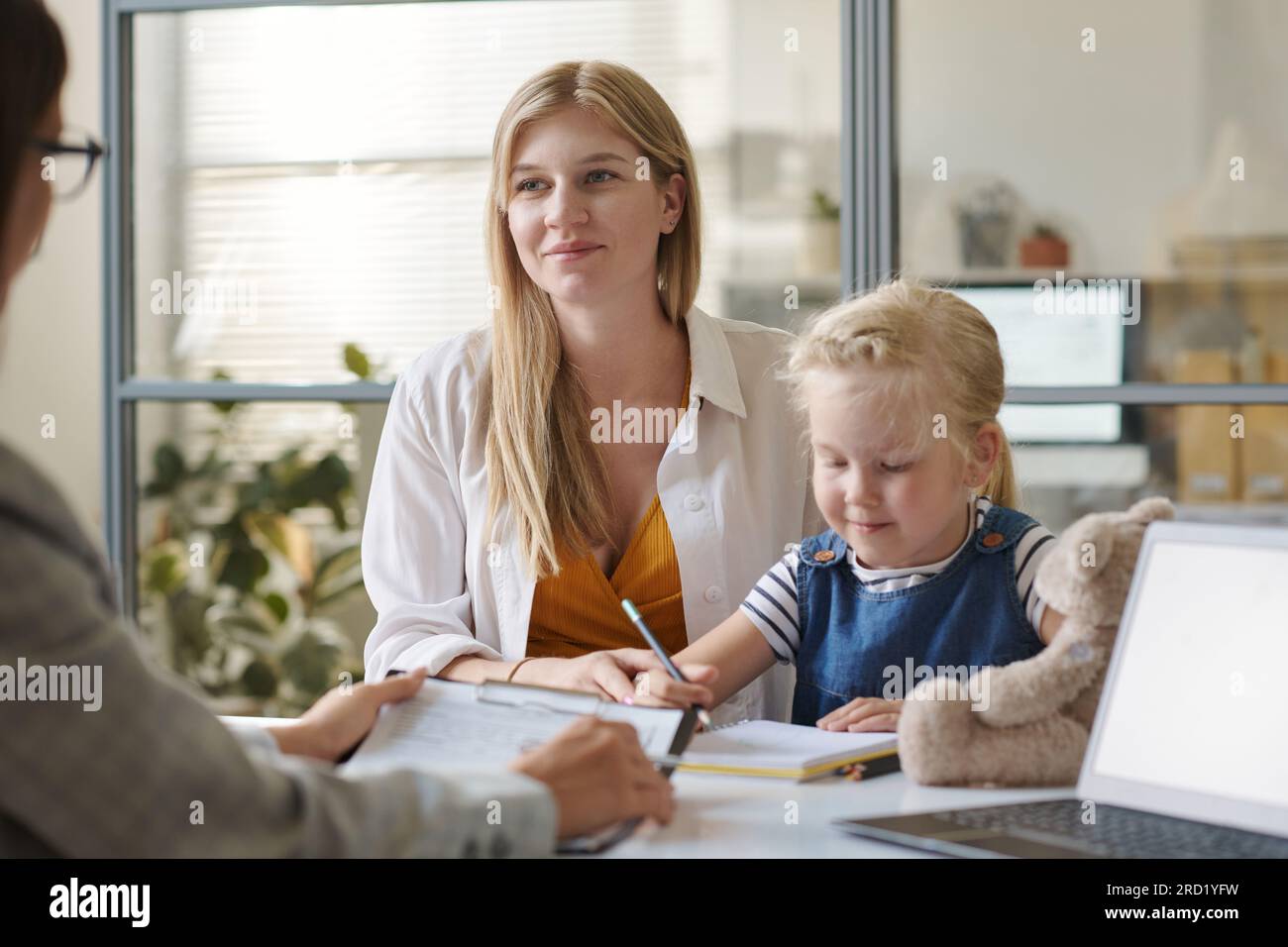 Single mother with child signing documents with social worker during ...