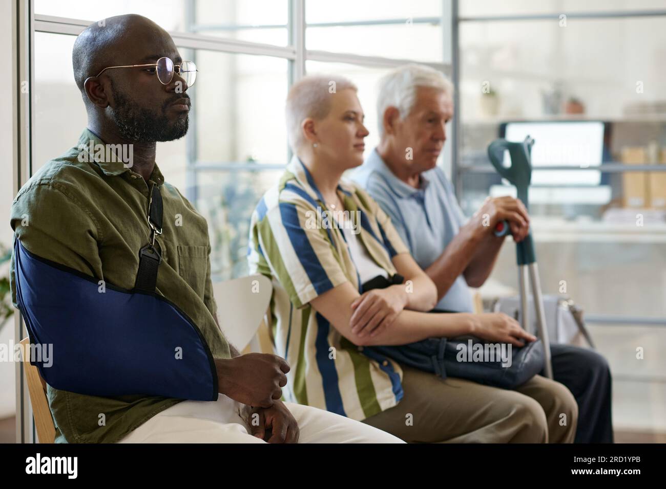 Group of people sitting in a queue and waiting for their consultation ...