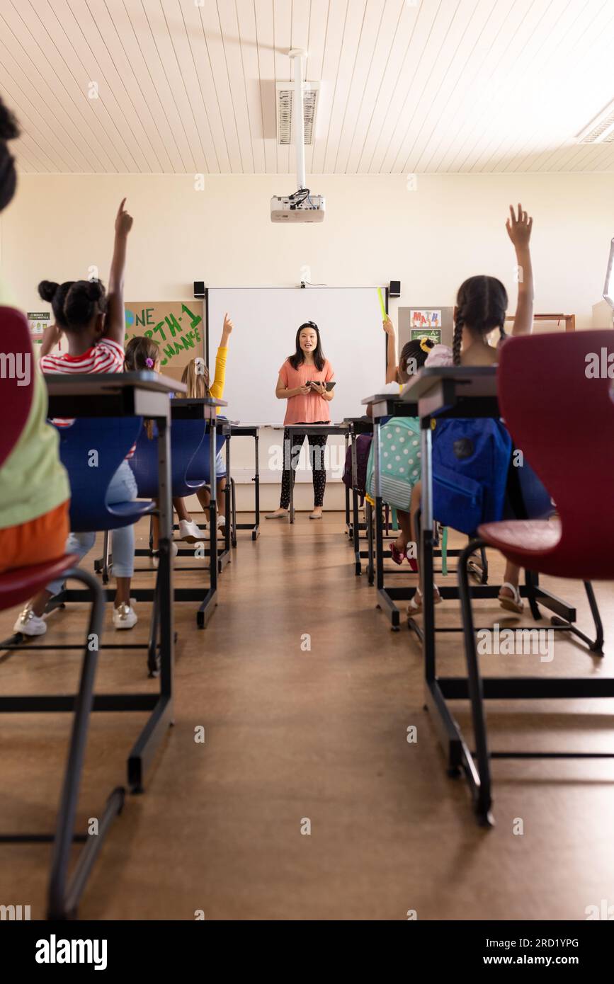 Diverse female teacher with tablet and elementary schoolchildren ...