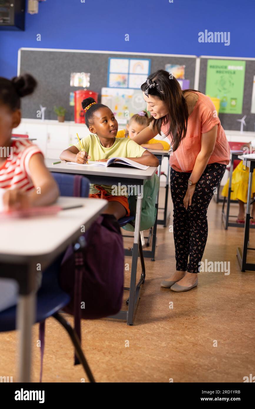 Diverse female teacher and schoolgirls in elementary school class Stock ...