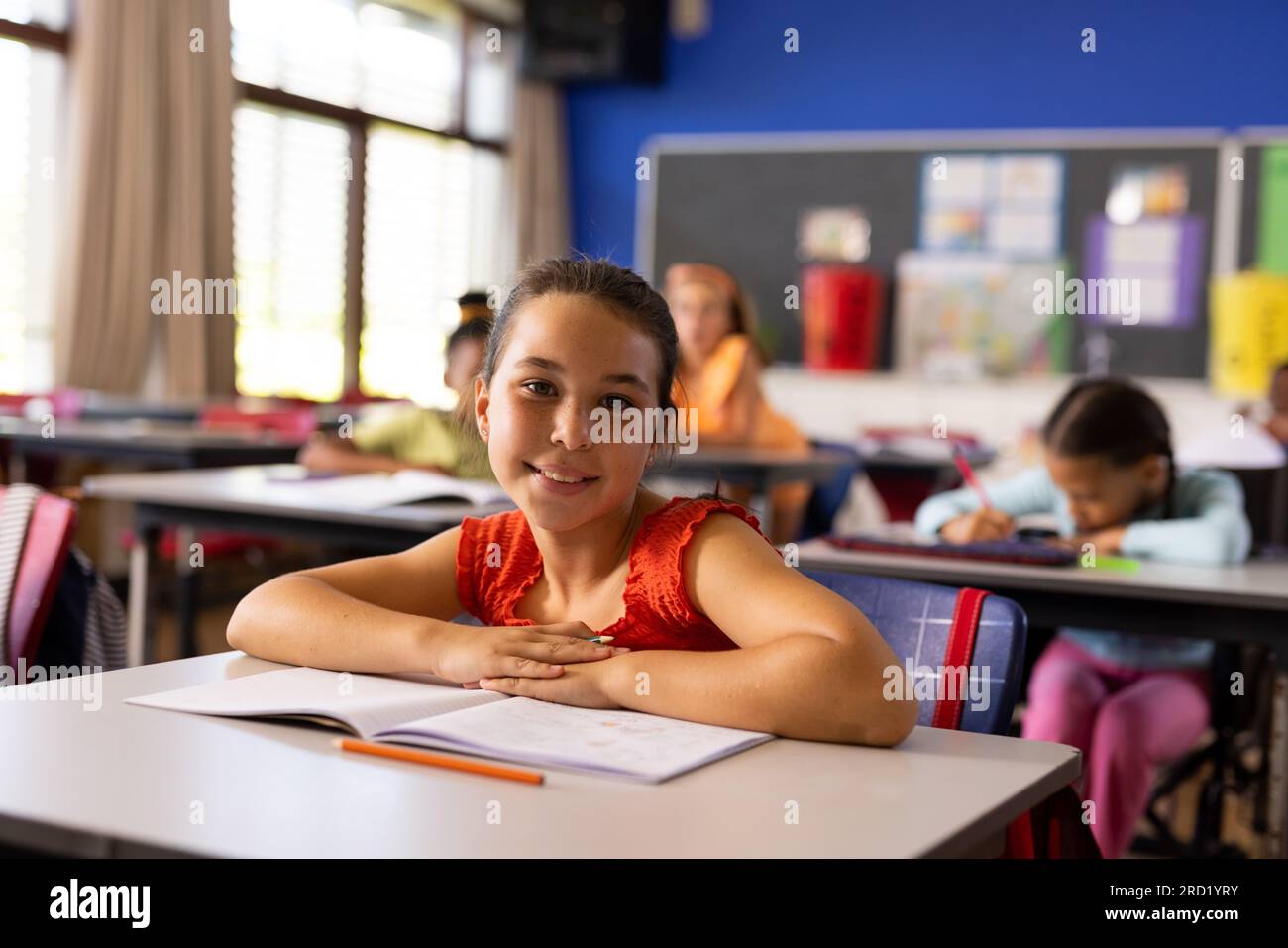 Portrait of happy caucasian schoolgirl in diverse elementary school ...