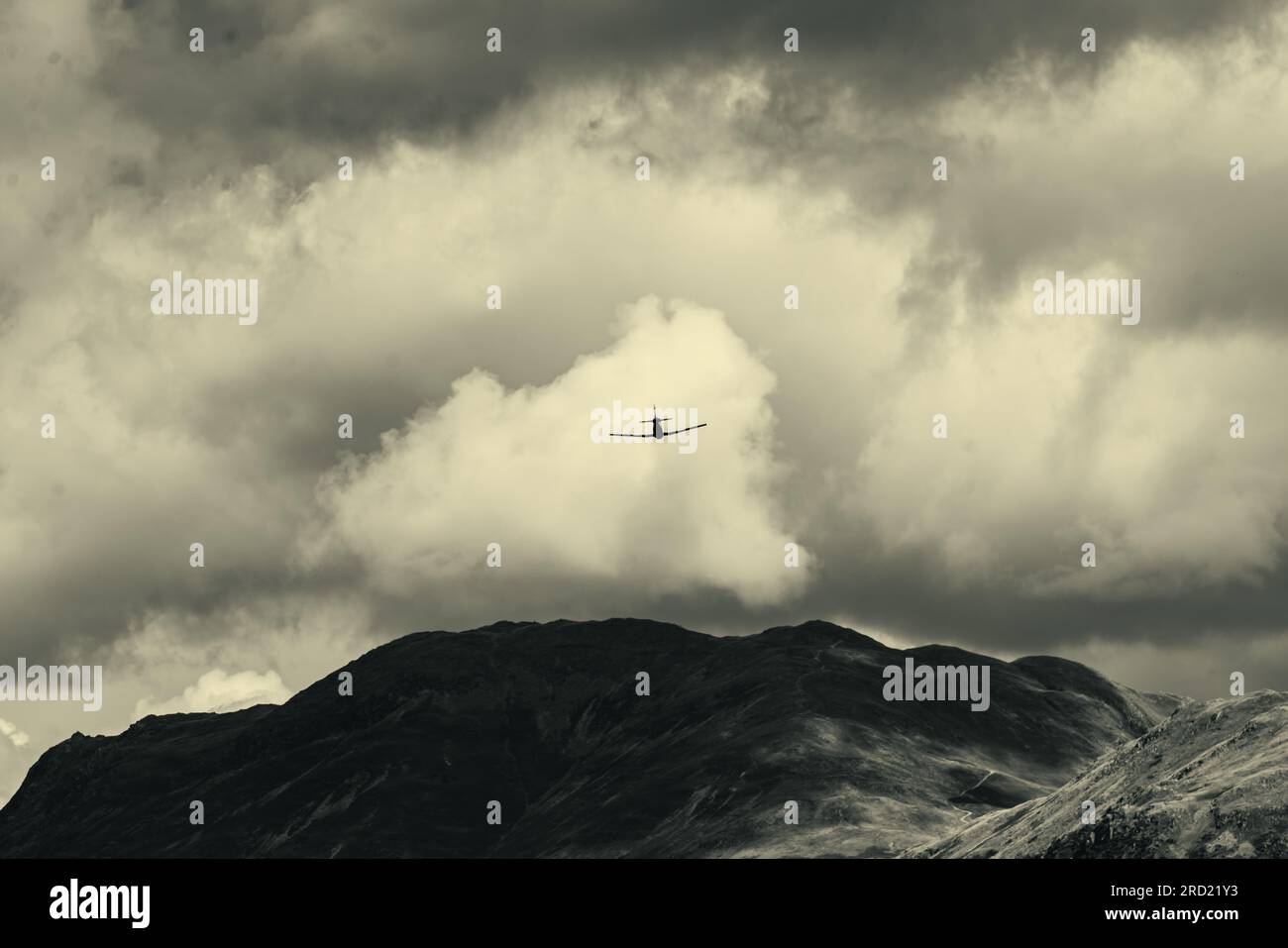 Old war plane flying over mountains in Penrith the lake district Stock ...