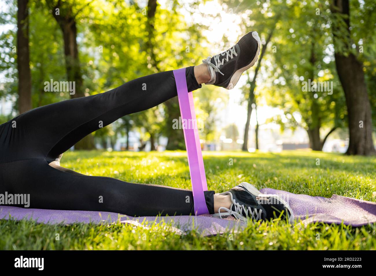 Girl legs with rubber elastic band during workout outdoors. Young ...