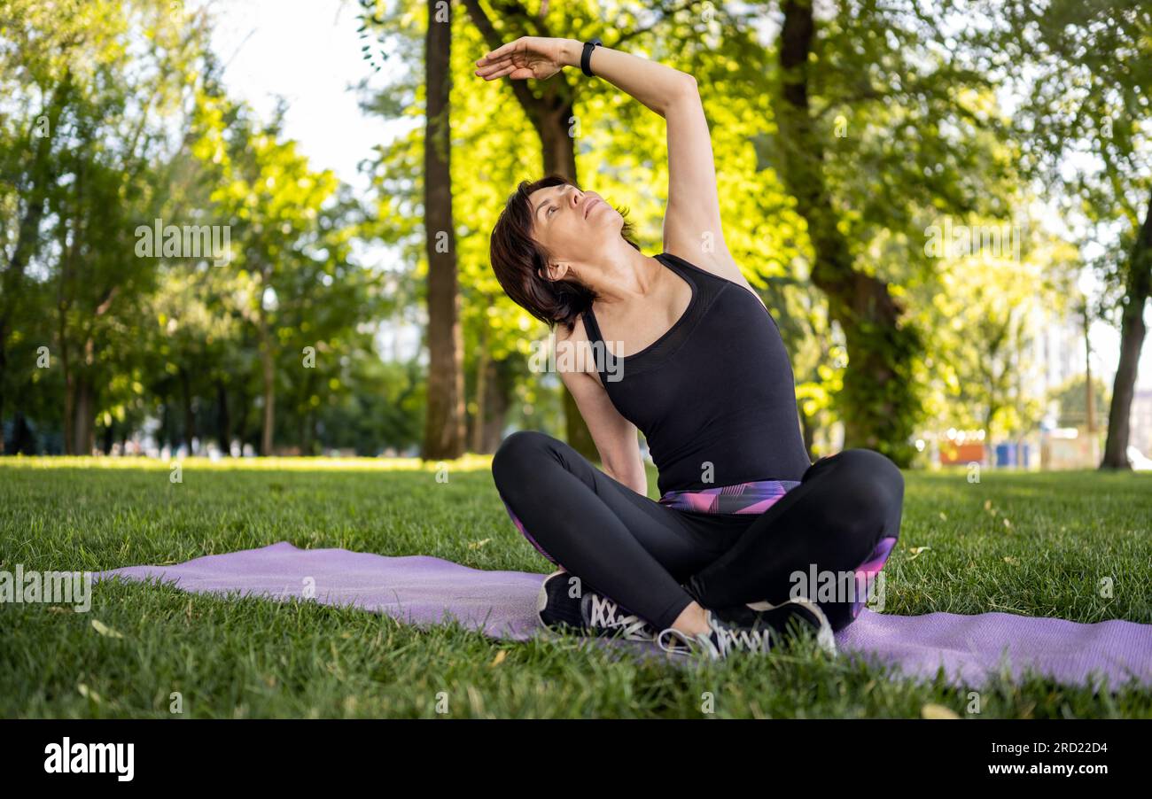 Girl doing morning yoga and strretching her back at park outdoors in ...