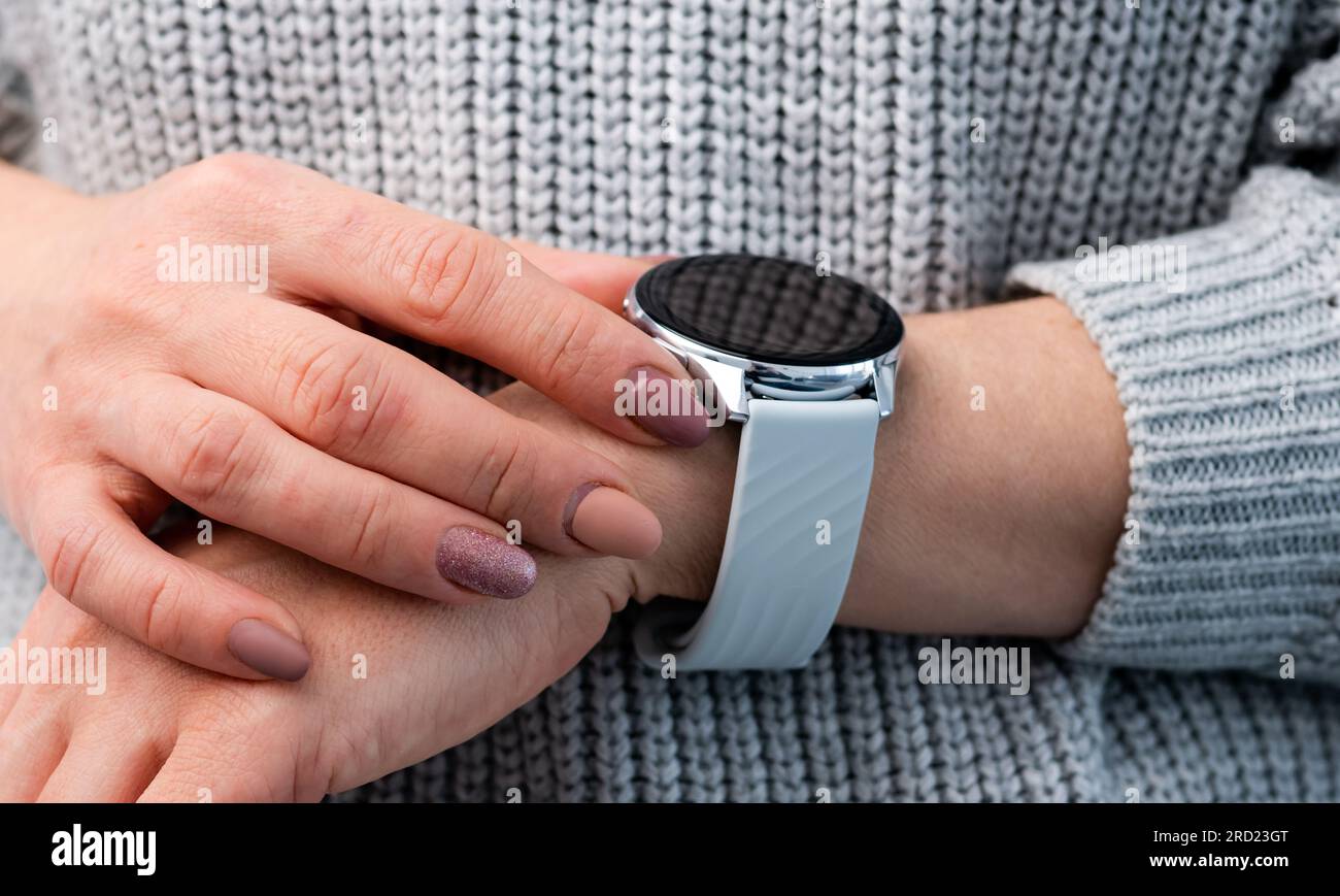 Person with smart watch on hand looking at time on digital screen with ...