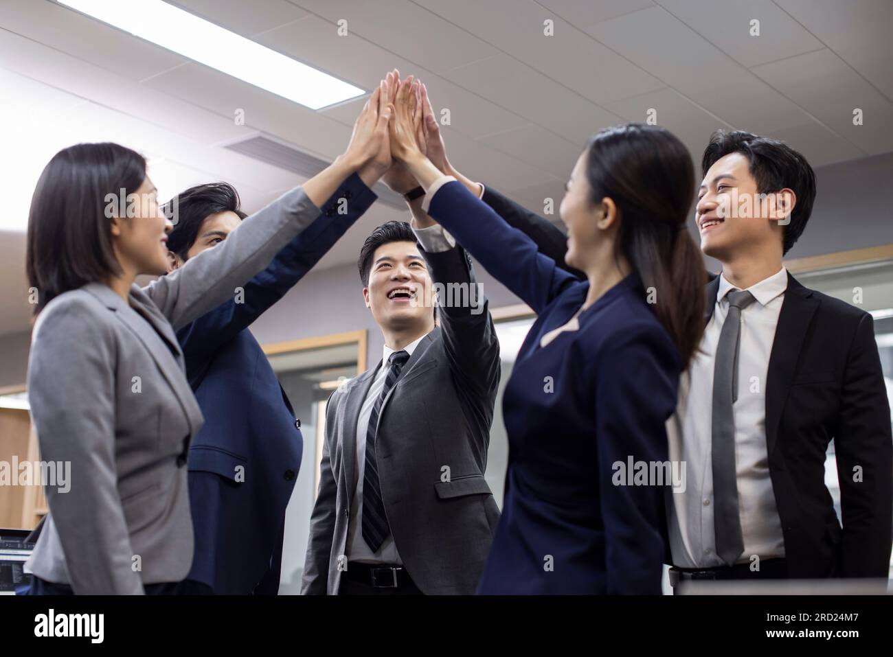 Confident Chinese business people cheering in office Stock Photo - Alamy