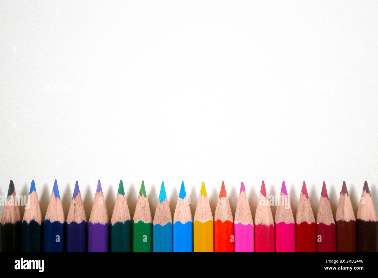Crayons in line on a blank sheet of paper Stock Photo - Alamy