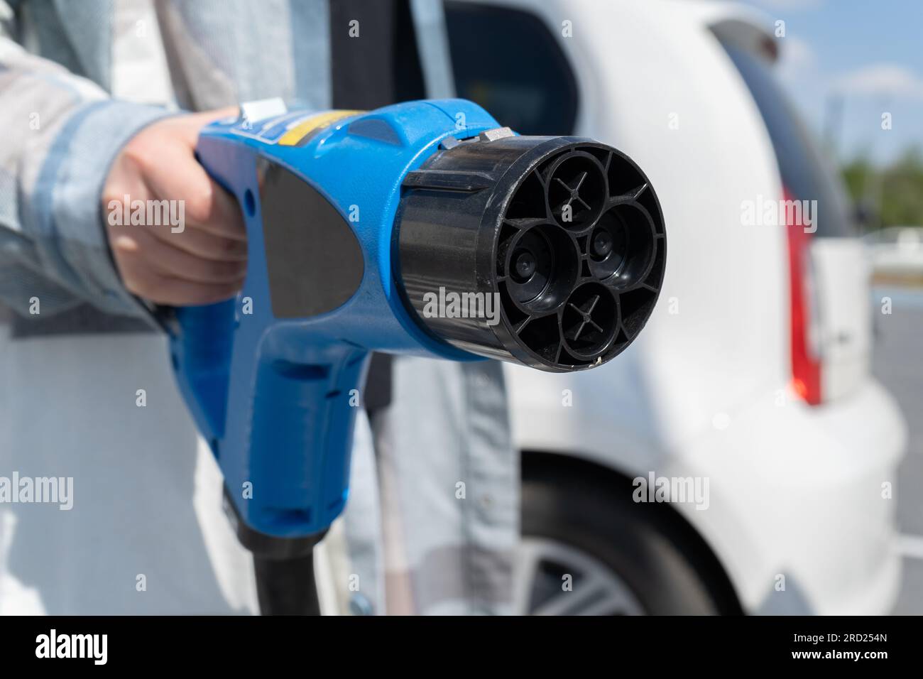 Woman holding fast charging socket CHAdeMO. Connector plug for electric ...