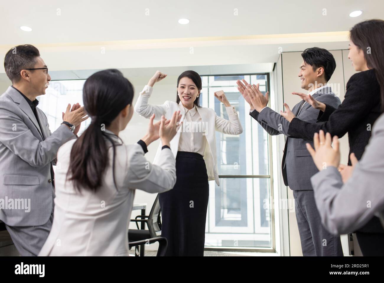 Cheerful Chinese business people applauding in office Stock Photo - Alamy