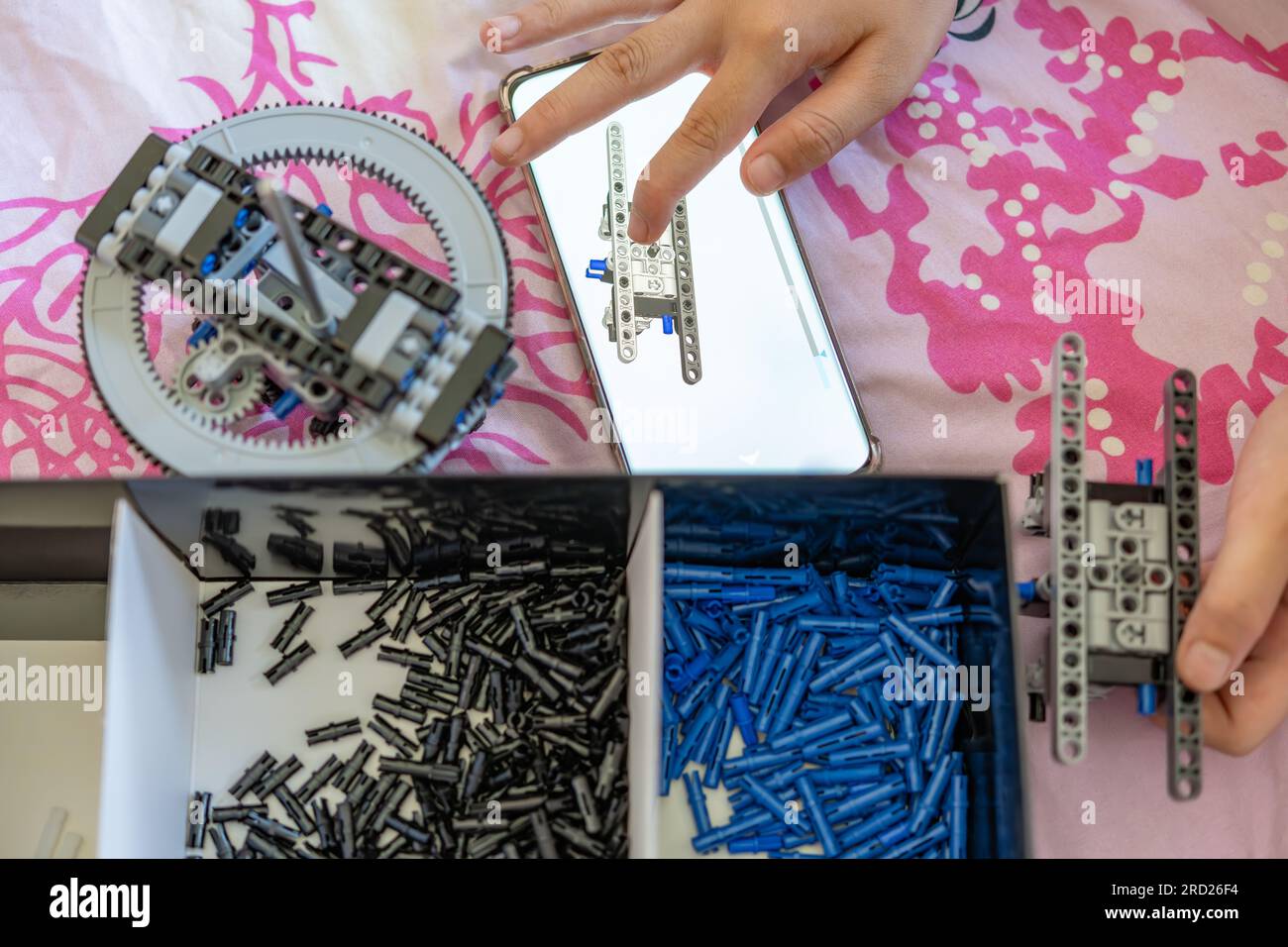 kid reading 3d electrical manuals via mobile and assembling toy bricks ...