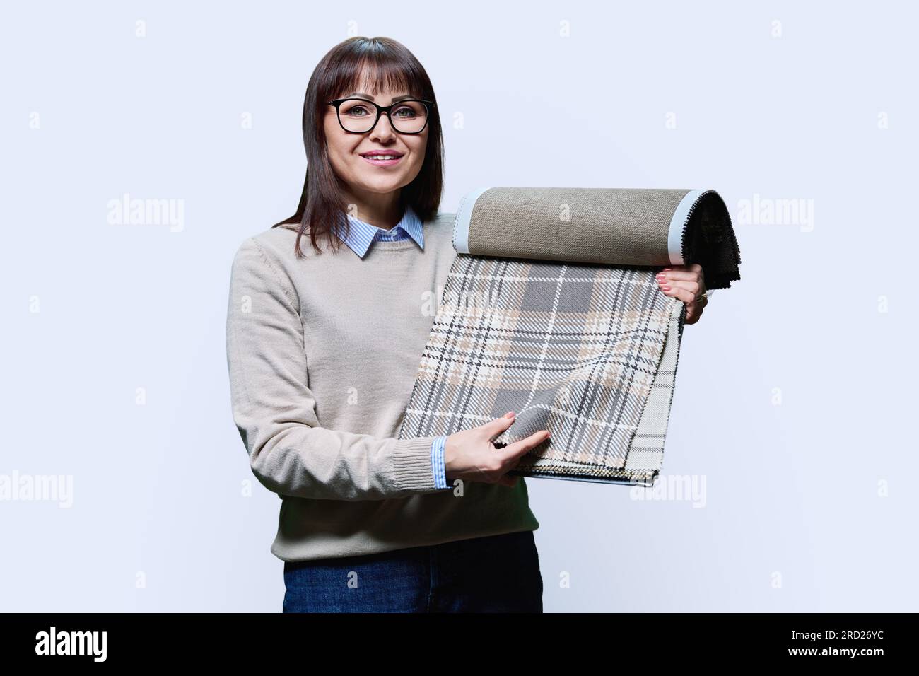 Woman with samples of fabrics for curtains and upholstery on white ...