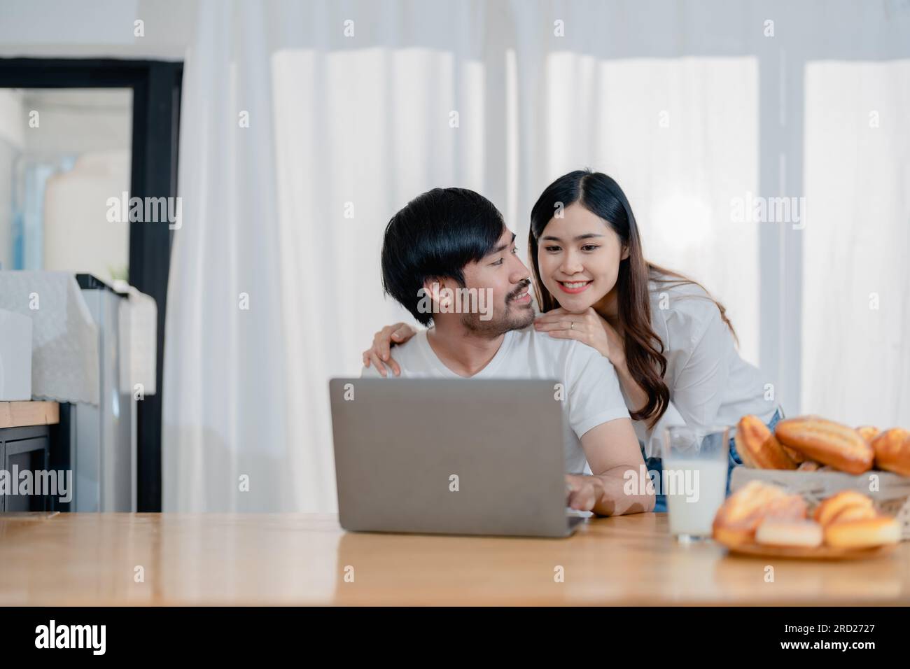 Happy young loving family couple looking at laptop computer screen ...
