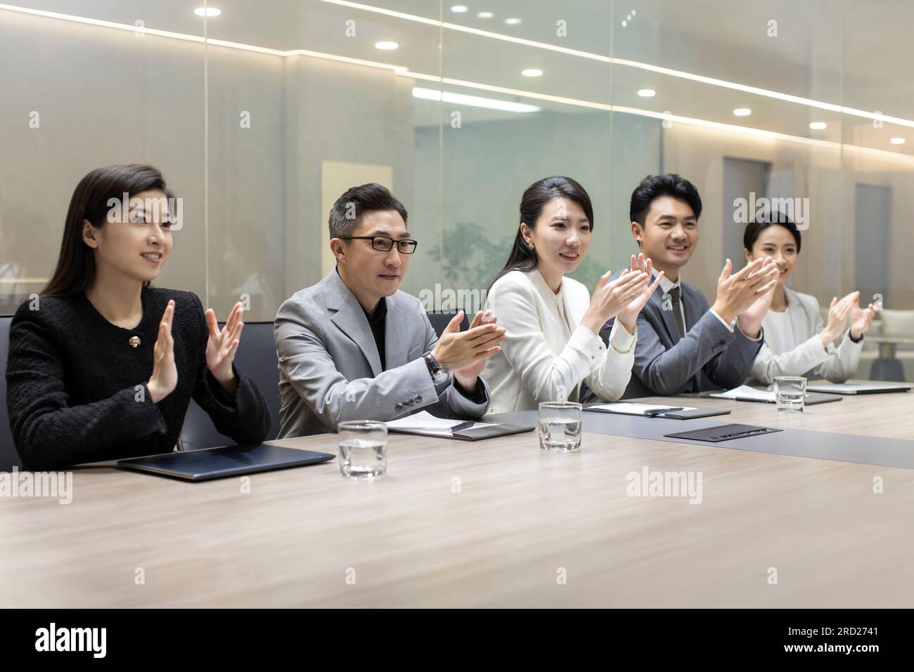 Cheerful Chinese business people applauding in meeting room Stock Photo ...