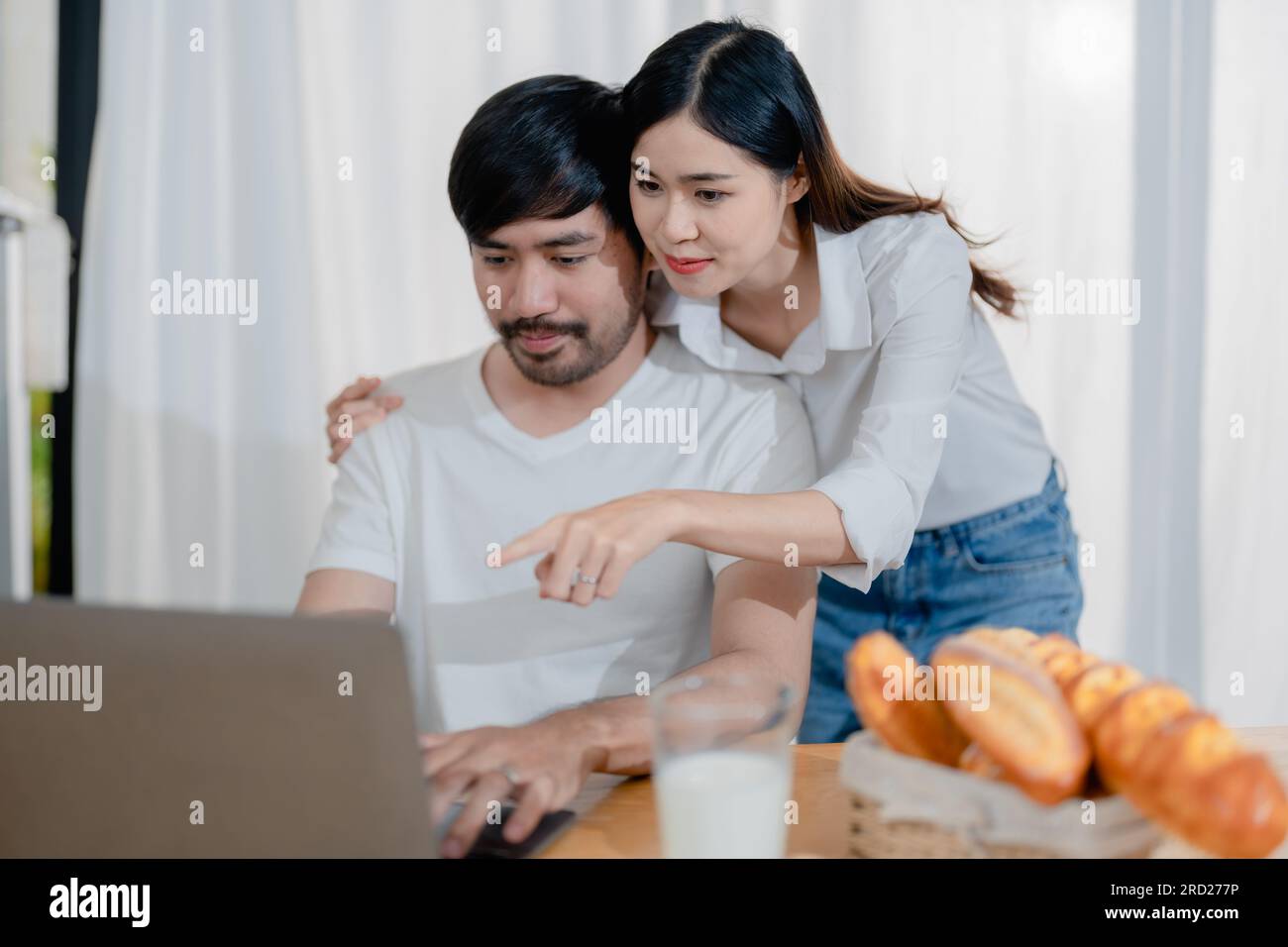 Happy young loving family couple looking at laptop computer screen ...
