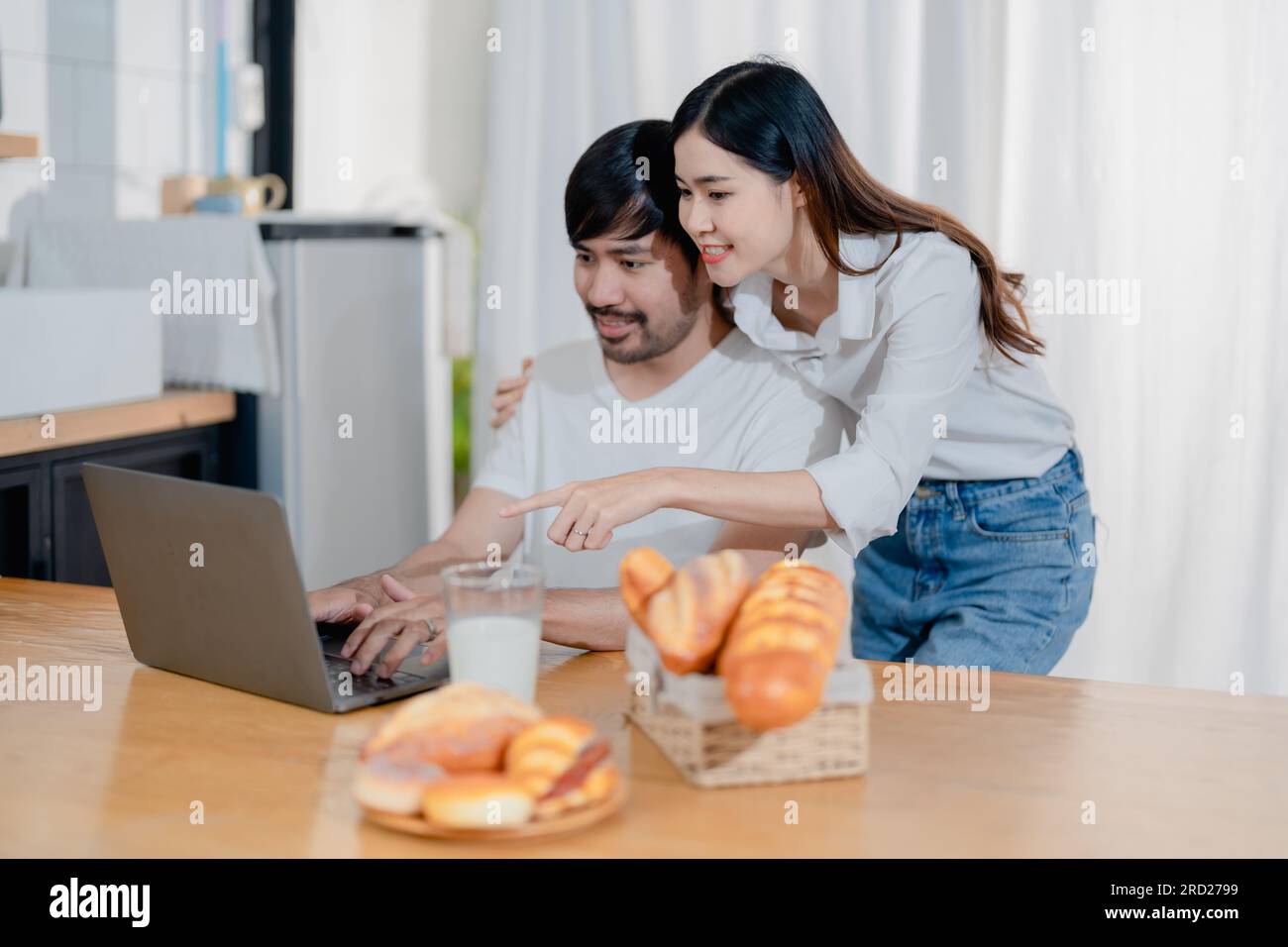Happy young loving family couple looking at laptop computer screen ...