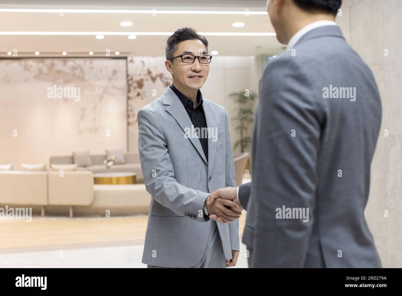 Successful Chinese business people shaking hands Stock Photo - Alamy