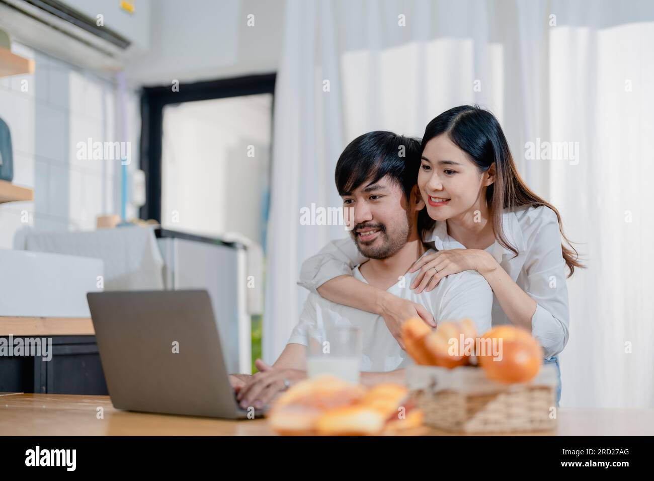 Happy young loving family couple looking at laptop computer screen ...