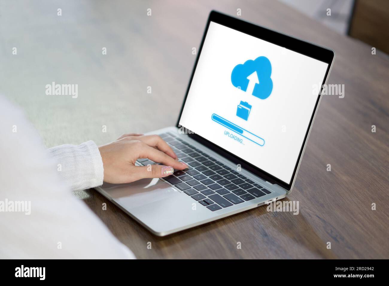 Woman uses her laptop showing a prominent cloud icon, a symbol for ...