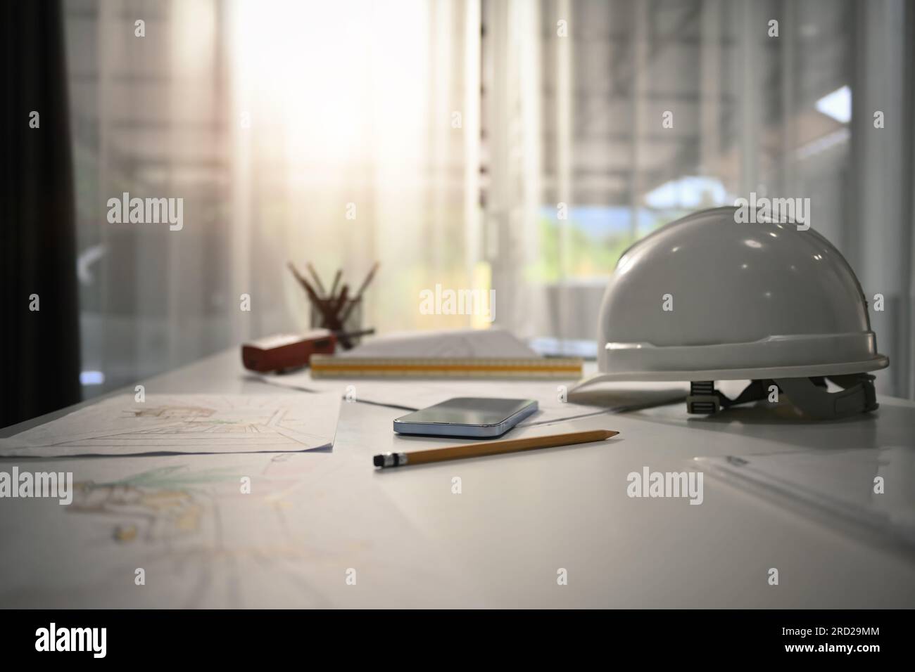 Safety helmets, blueprints and smartphone on the engineering desks ...