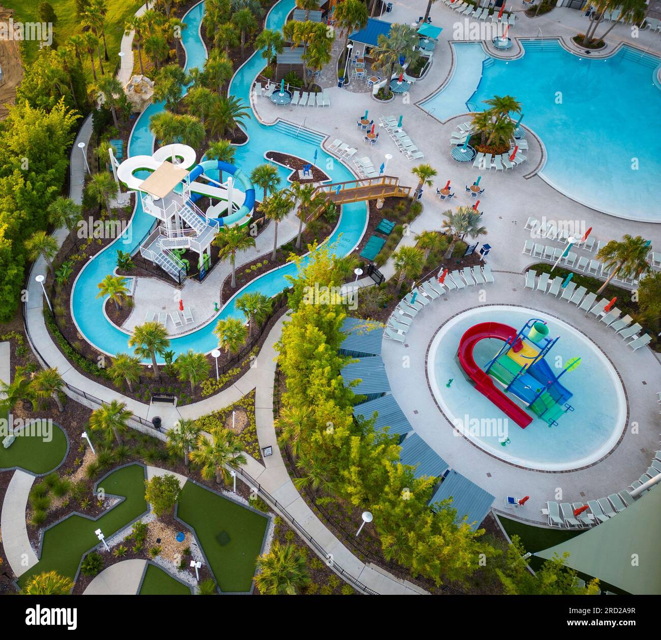 Looking down at a resorts pool area with water slides, a lazy river ...
