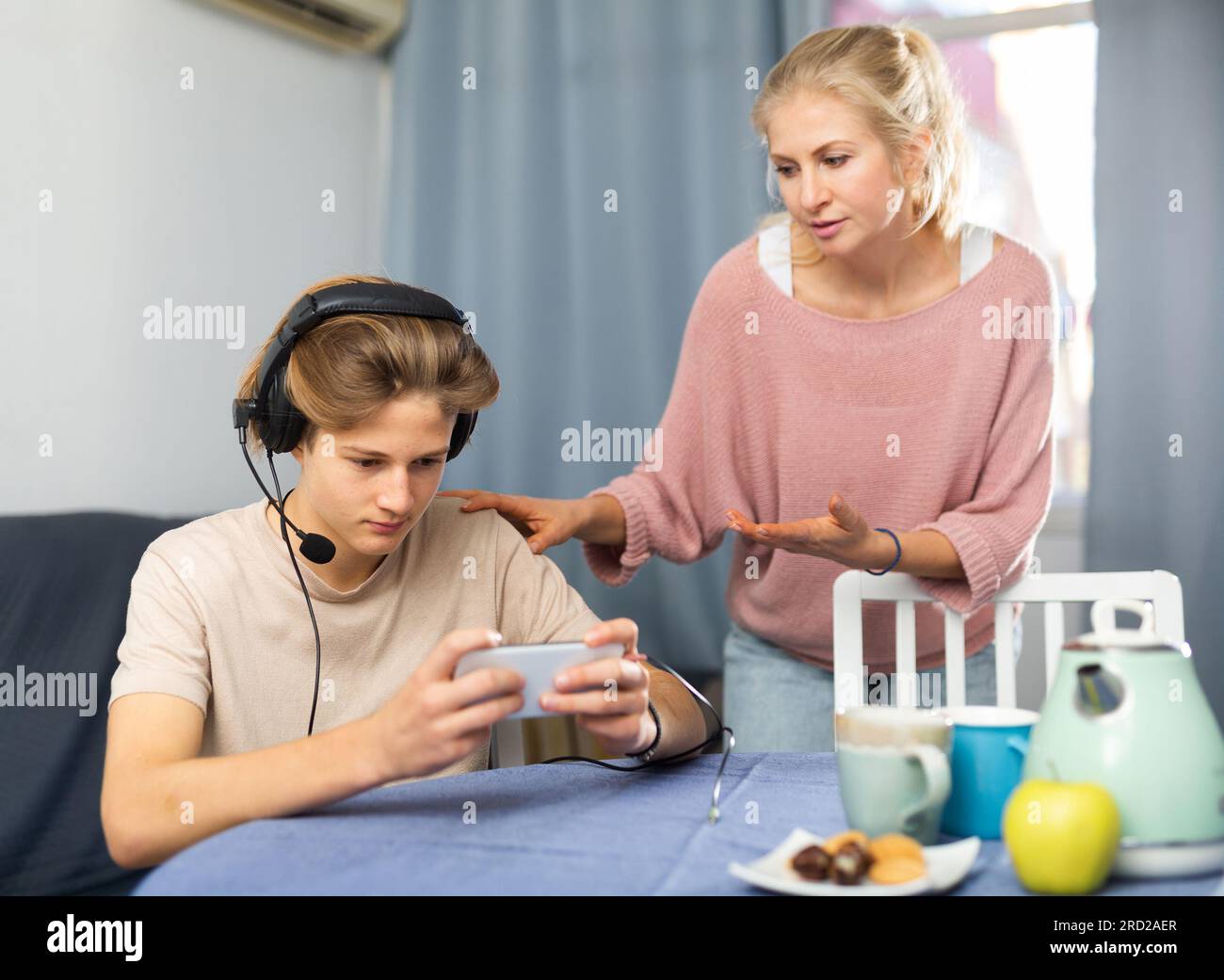 Mother asking for attention of her teenager son Stock Photo - Alamy