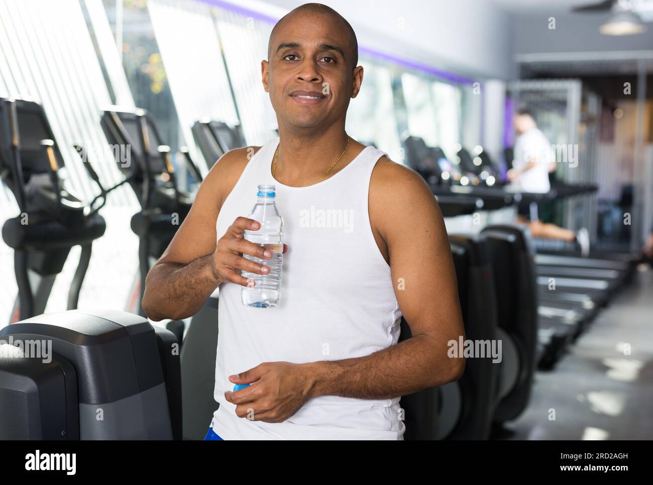 Man drinking water after exercises in gym Stock Photo - Alamy