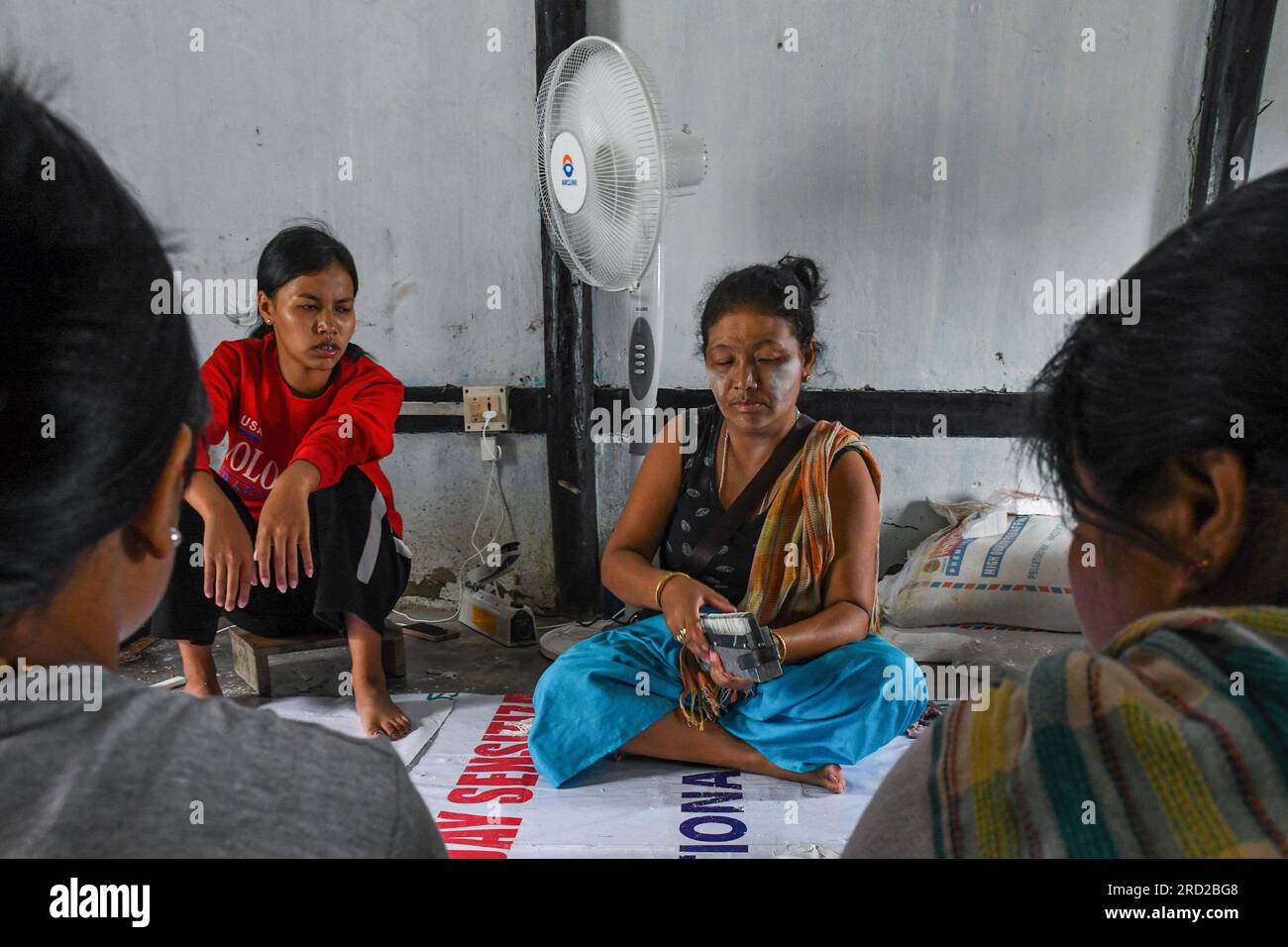 Imphal, India. 15th July, 2023. A Meitei woman demonstrates a candle ...