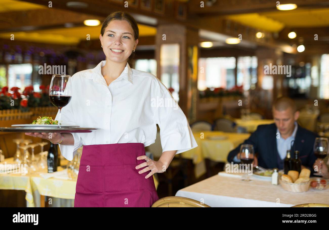 Waiter standing with serving tray, recommending dishes in restaurant ...