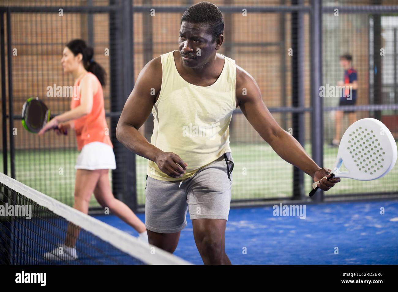 African american paddle tennis player preparing to hit ball on court ...