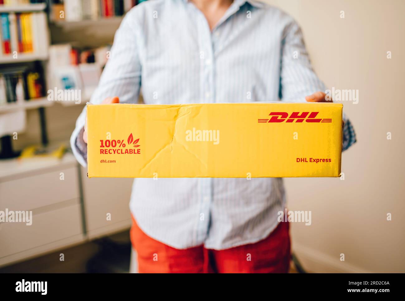 Hamburg, Germany - June 11, 2023: Woman receiving yellow DHL Express ...