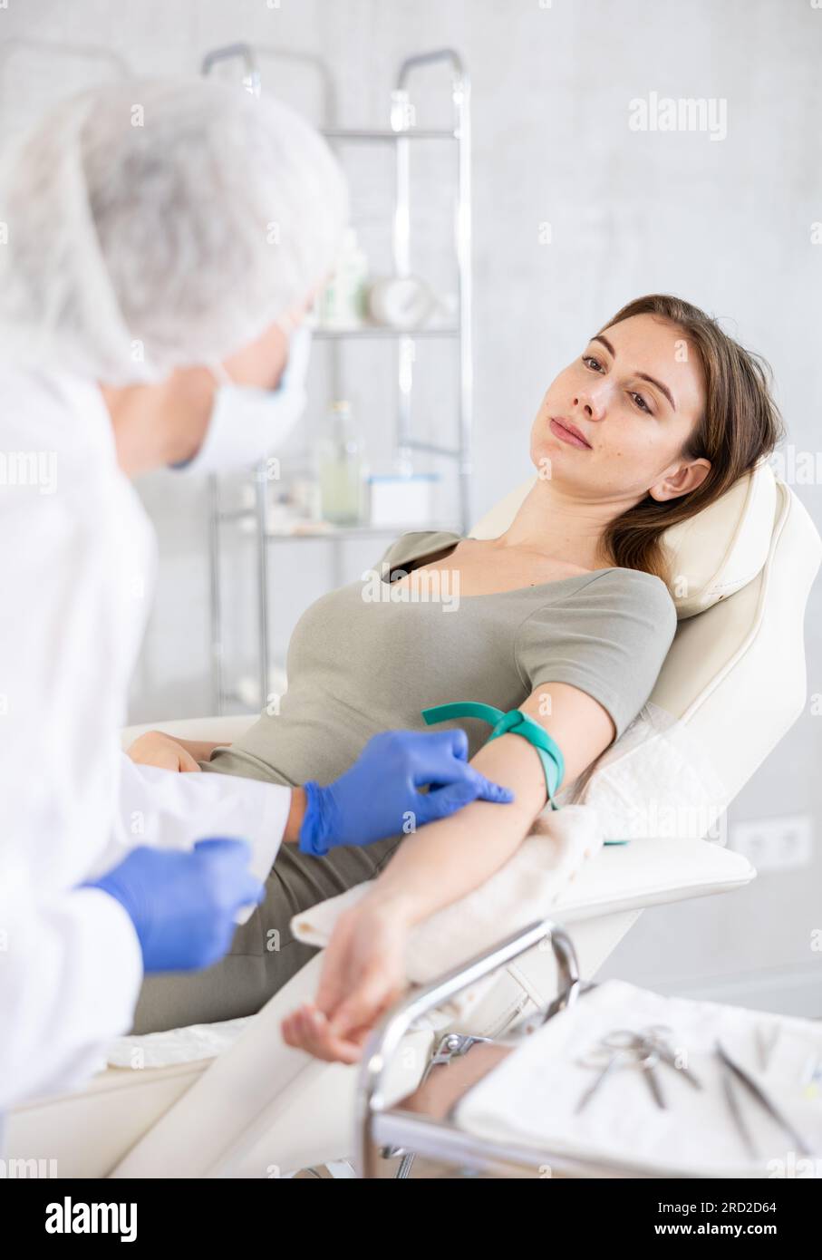 Elderly doctor drawing blood from young patient Stock Photo - Alamy