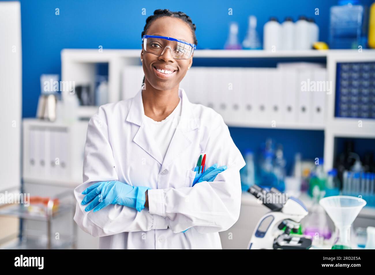 African american woman scientist smiling confident standing with arms crossed gesture at ...