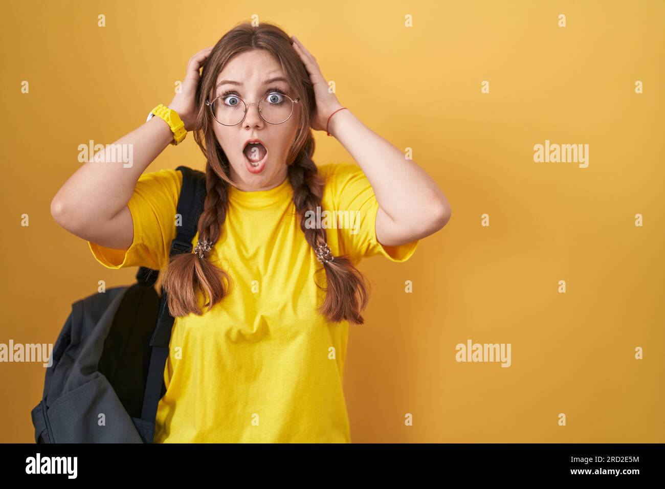 Young caucasian woman wearing student backpack over yellow background ...