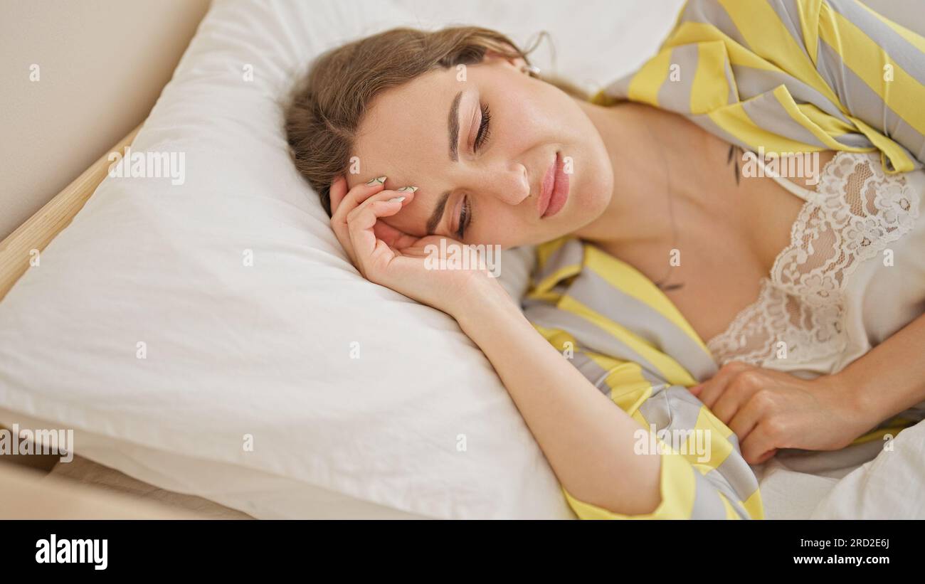 Young blonde woman stressed lying on bed crying at bedroom Stock Photo ...