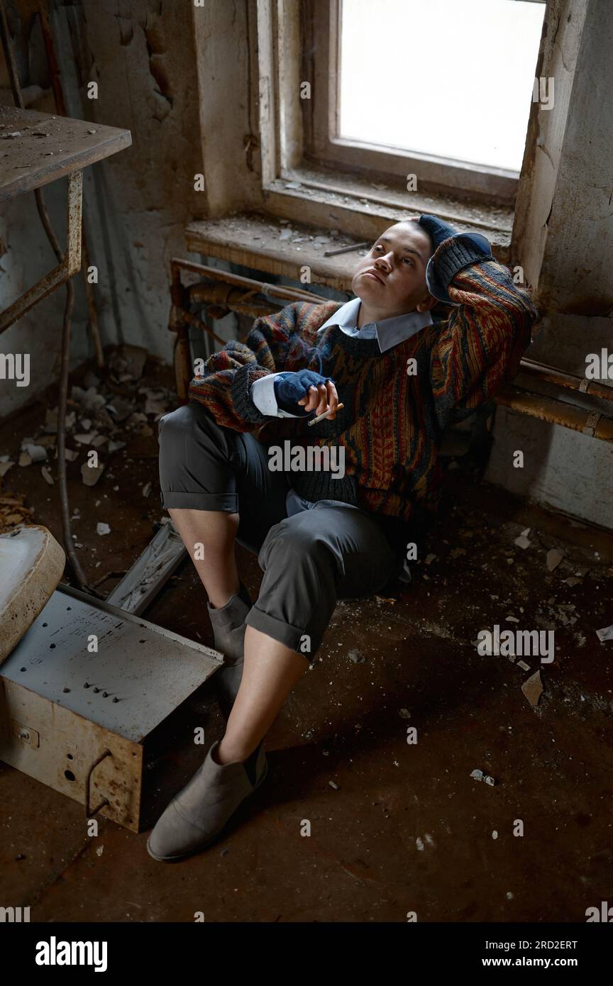 Girl in old dirty, ragged clothes smoking cigarette, selective focus ...