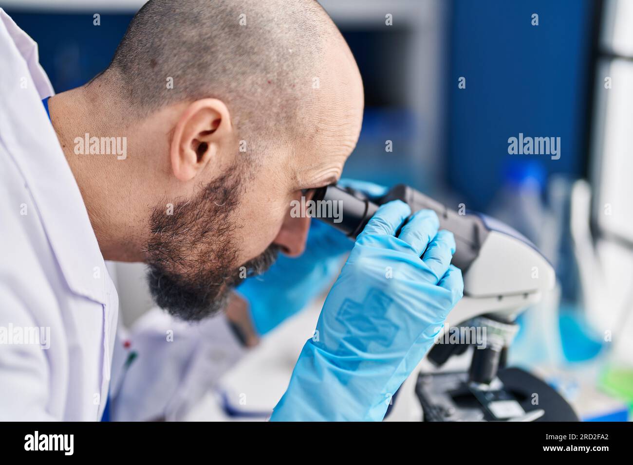 Young bald man scientist using microscope at laboratory Stock Photo - Alamy