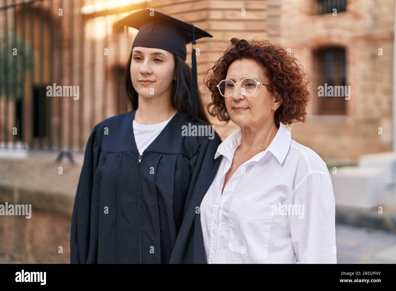 Two women mother and daughter celebrating graduation at campus ...