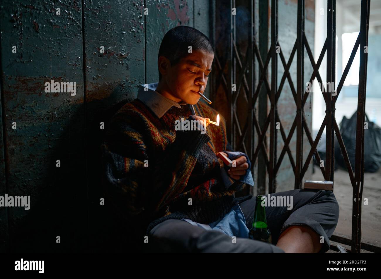 Homeless woman smoker holding cigarette looking at burning match in ...